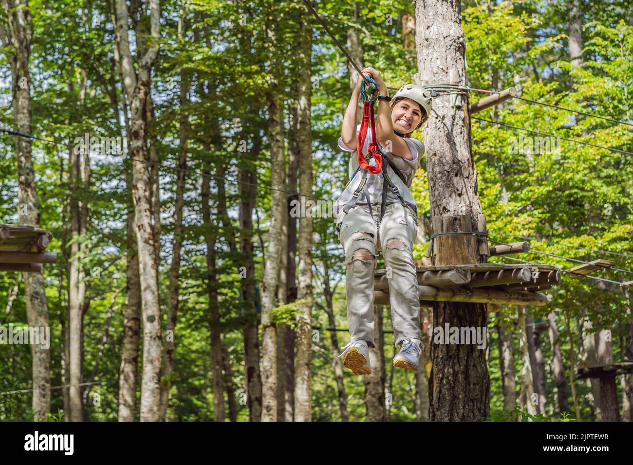 Happy women girl female gliding climbing in extreme road trolley ...