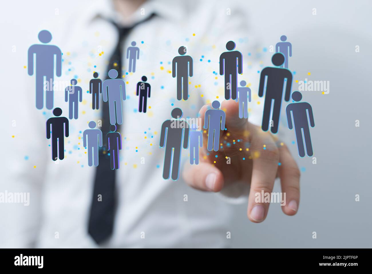 A man's hand pressing a group of illustrative human figures against a ...