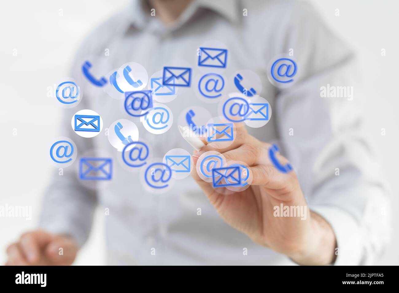 A man's hand pressing a group of illustrative email and call icons ...