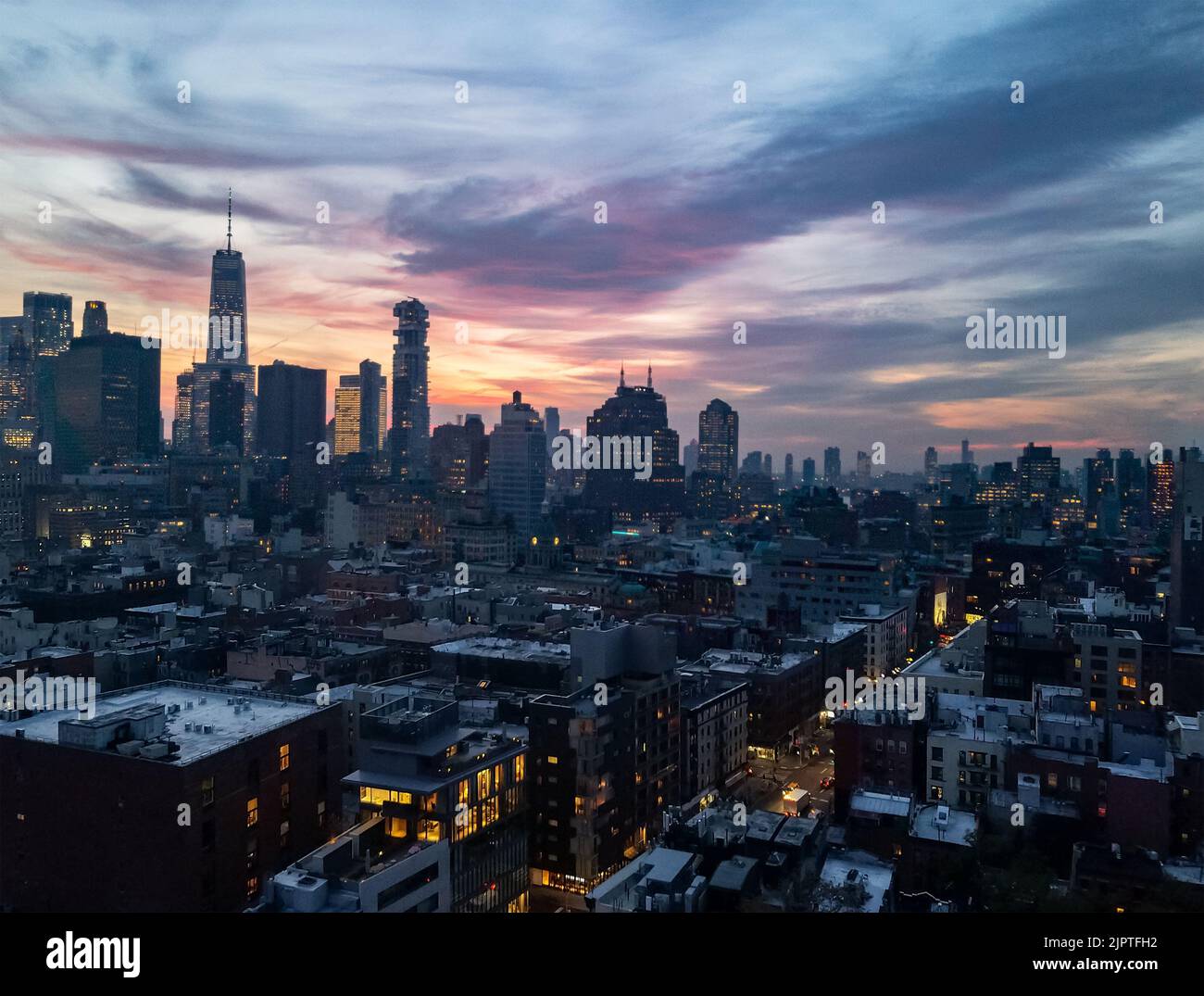 New York City skyline lights at dusk with colorful sky above the ...