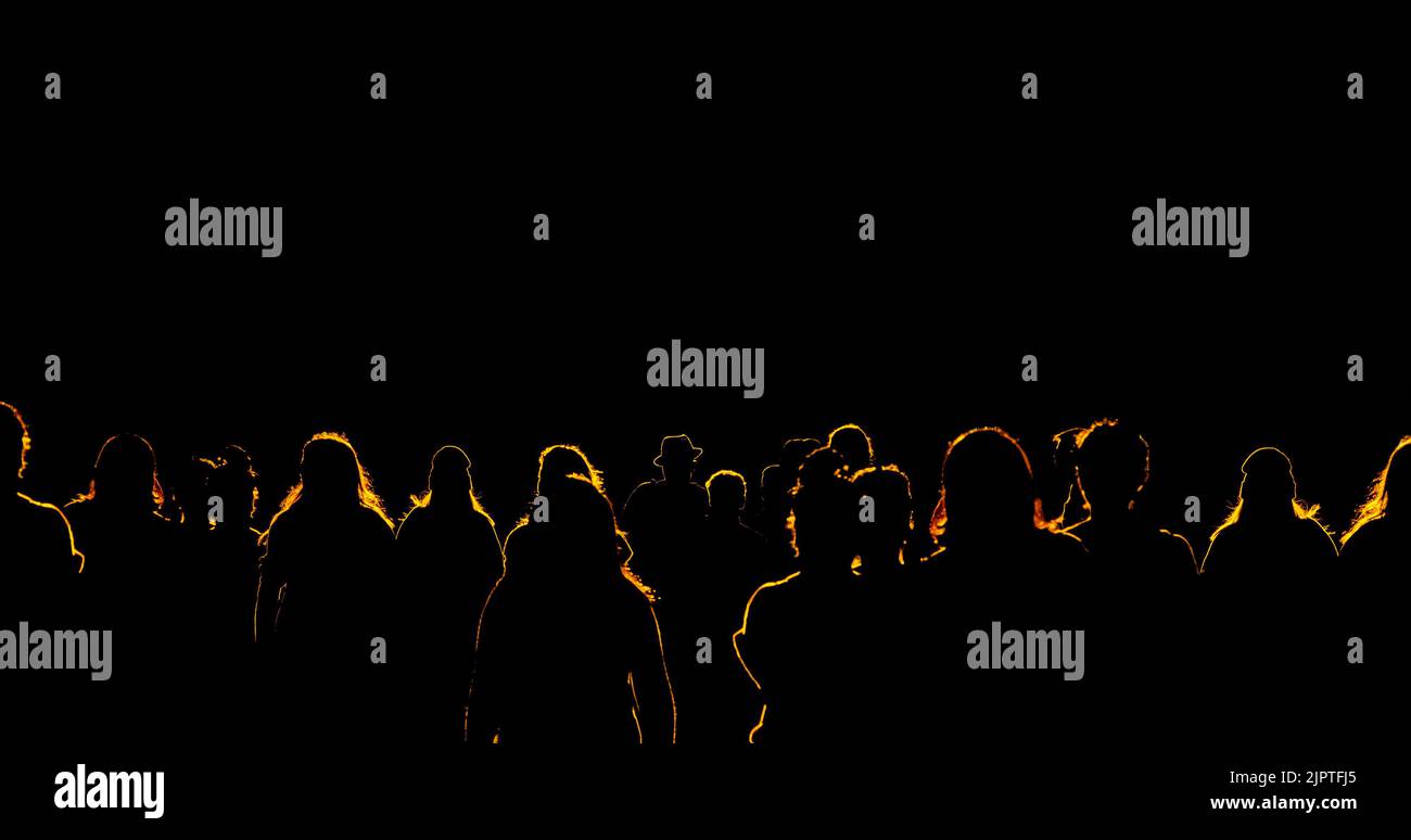 Light shining on crowd of people with yellow outlined silhouettes of ...