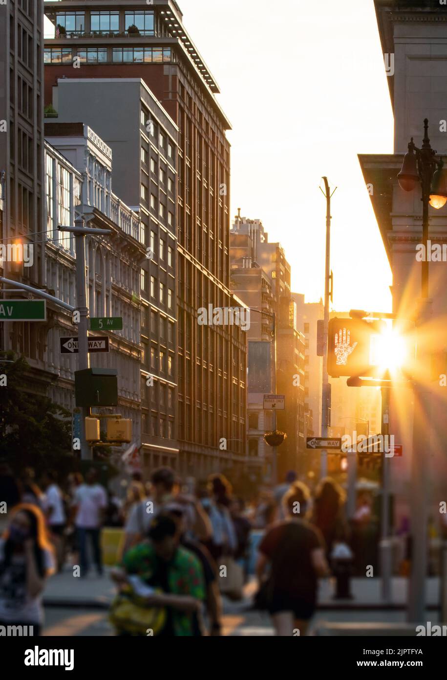 Crowds of people walking down the busy street with sunlight shining ...