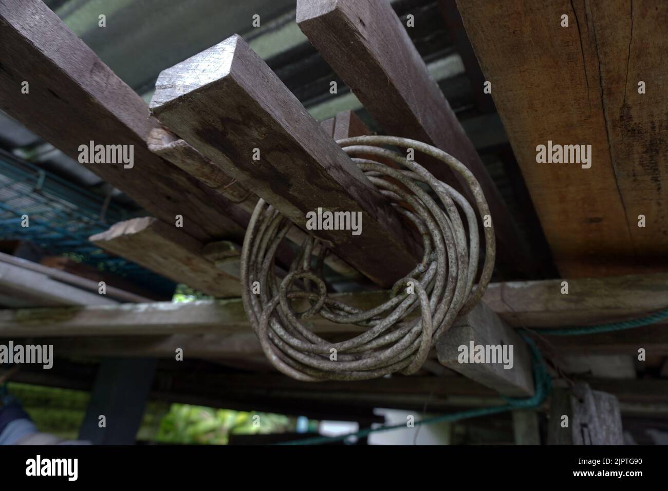 An old electrical wire is hung from a log Stock Photo - Alamy
