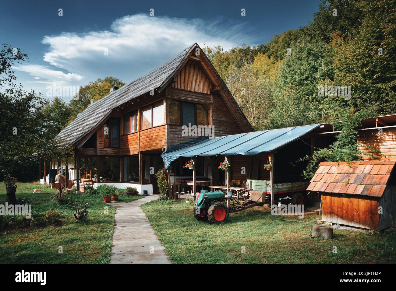 Rural farm in the mountains, near the forest, blue sky and clouds ...
