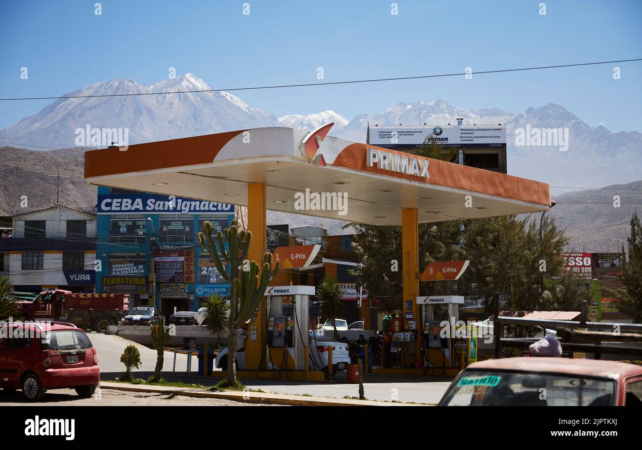 Many cars at a gas station in the background of the volcano Misti in ...
