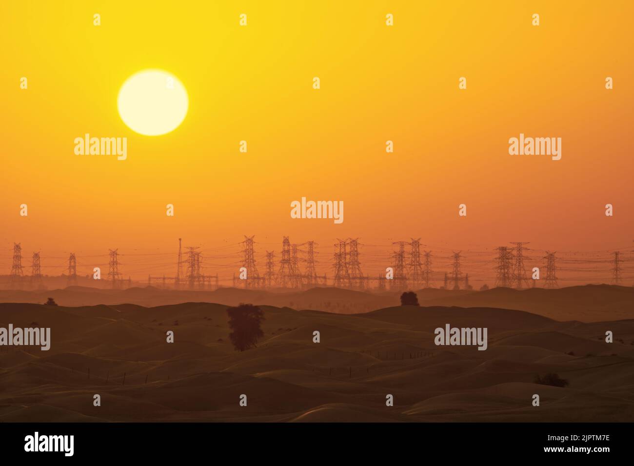 The sun over rows of power towers on a landscape during sunset Stock ...
