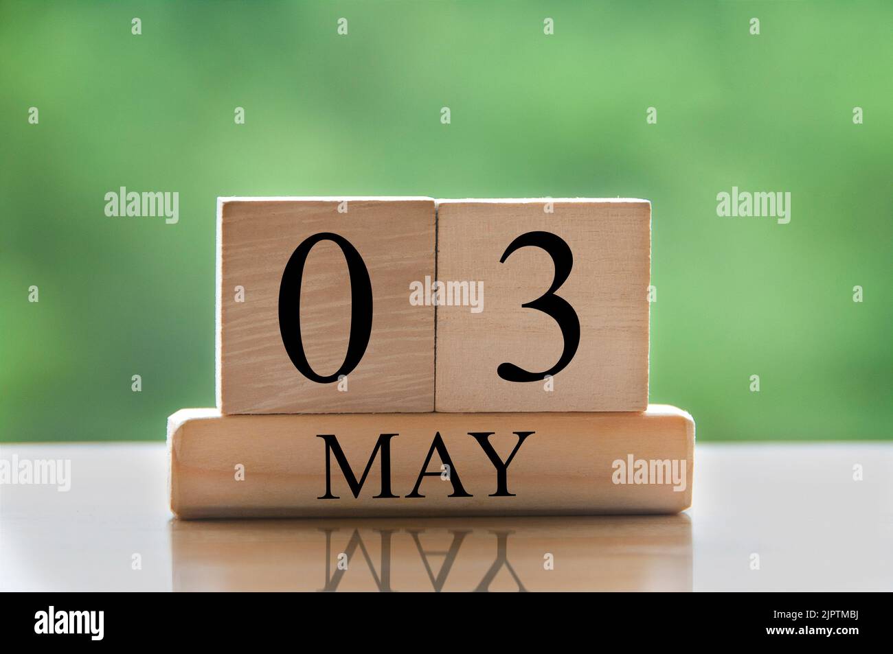 May 3 calendar date text on wooden blocks with blurred nature ...