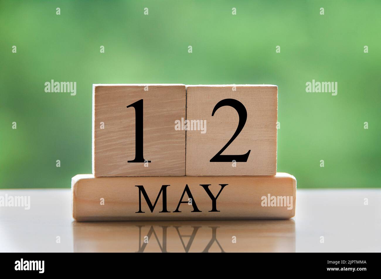 May 12 calendar date text on wooden blocks with blurred nature ...
