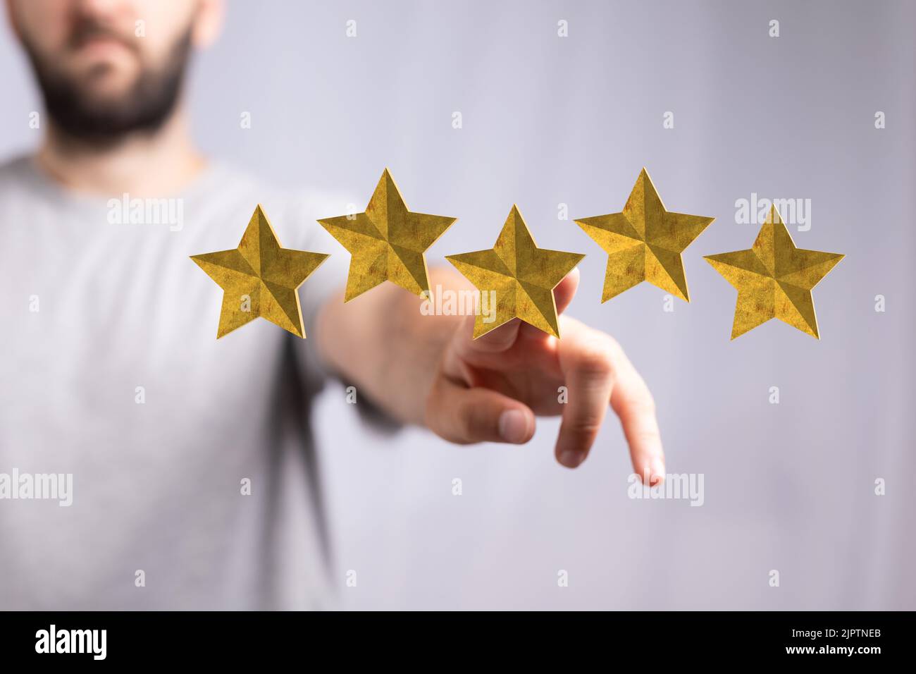 A man's hand pointing at 3d rendered gold stars Stock Photo - Alamy
