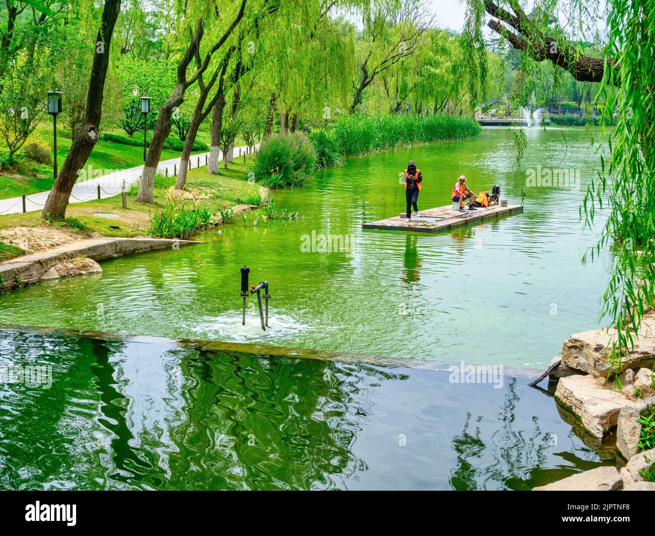 Furong Lake by the Tang Paradise. Two man moving in a motorized raft ...