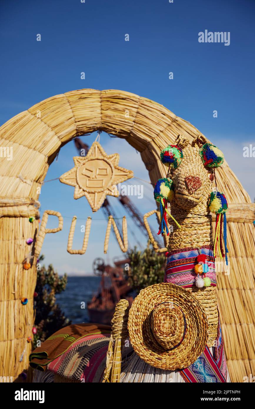 A vertical shot of a fabric camel by the entrance of the Puno lake ...