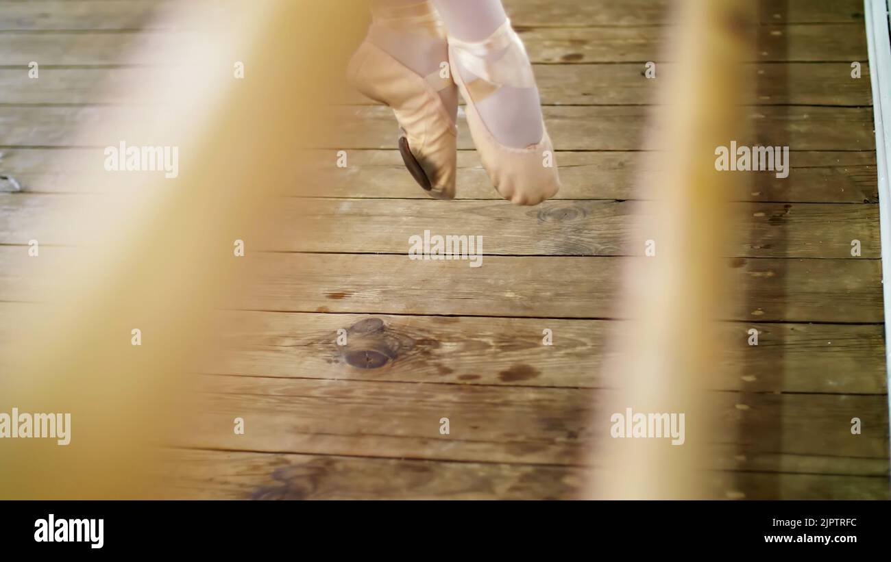close up, in dancing hall, ballerina performs pas soute, jumping in ...