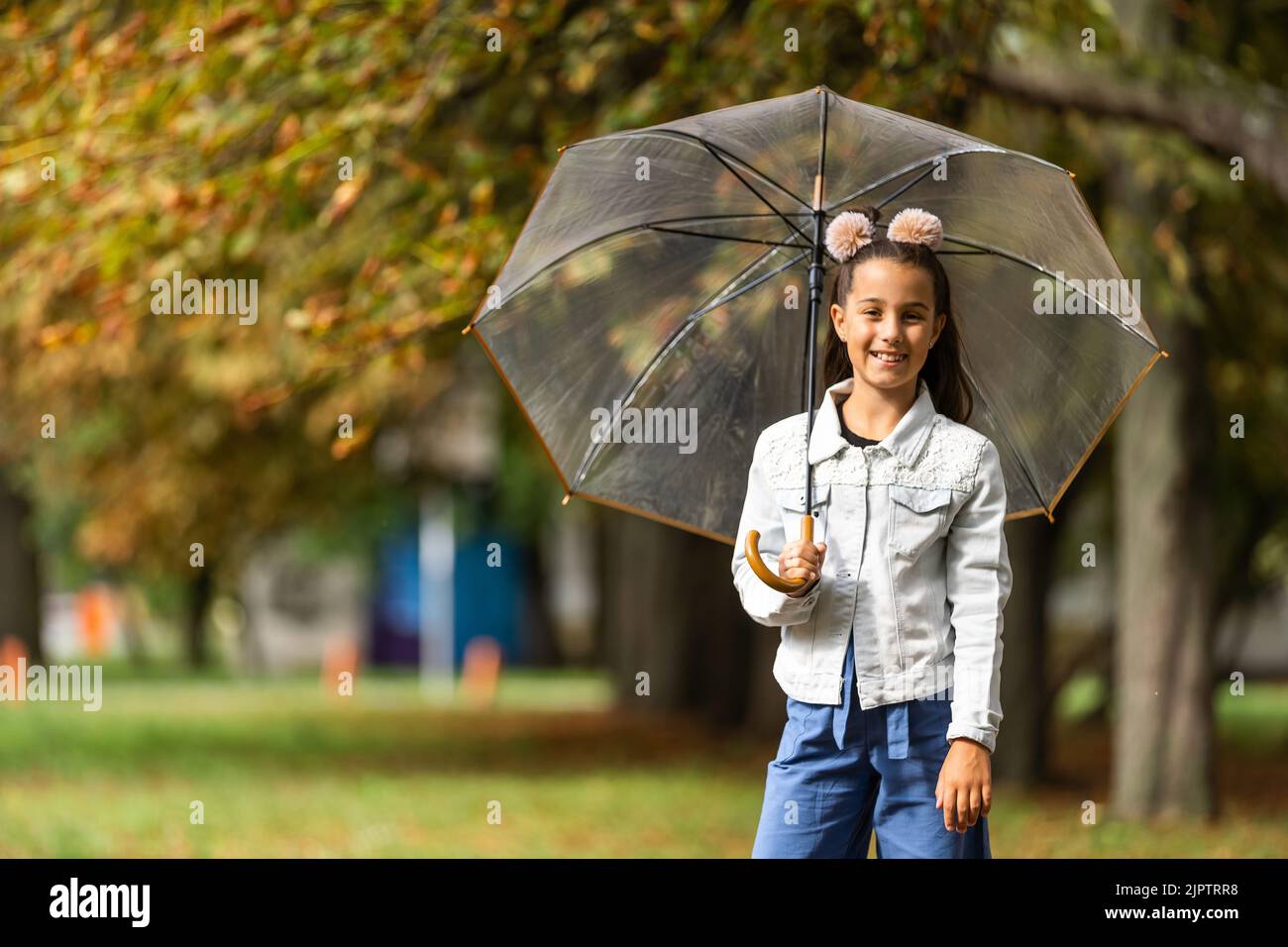 Little child walking with umbrella in the rain in fall park Stock Photo ...