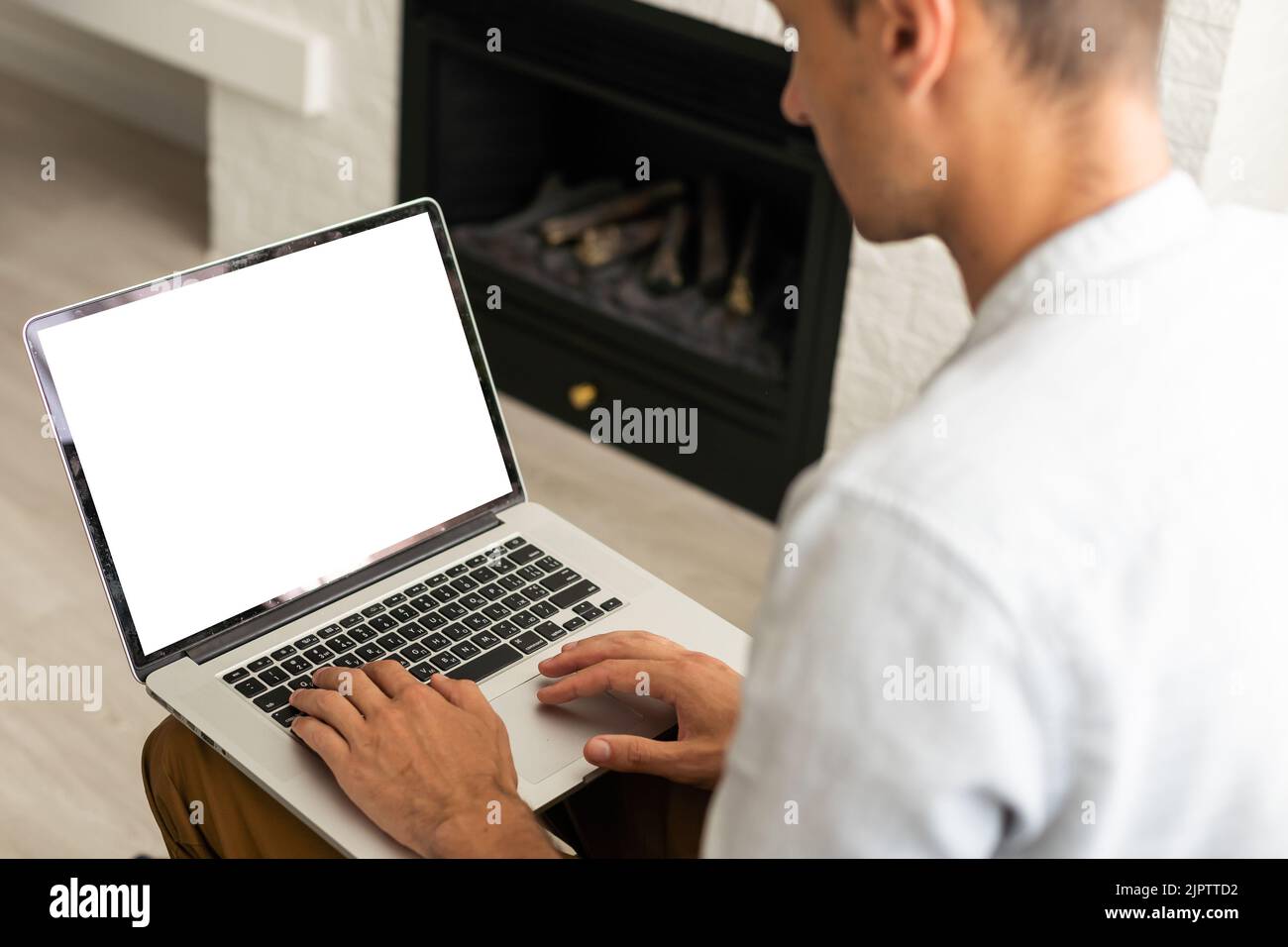 Young male tech user relaxing on sofa holding laptop computer mock up ...