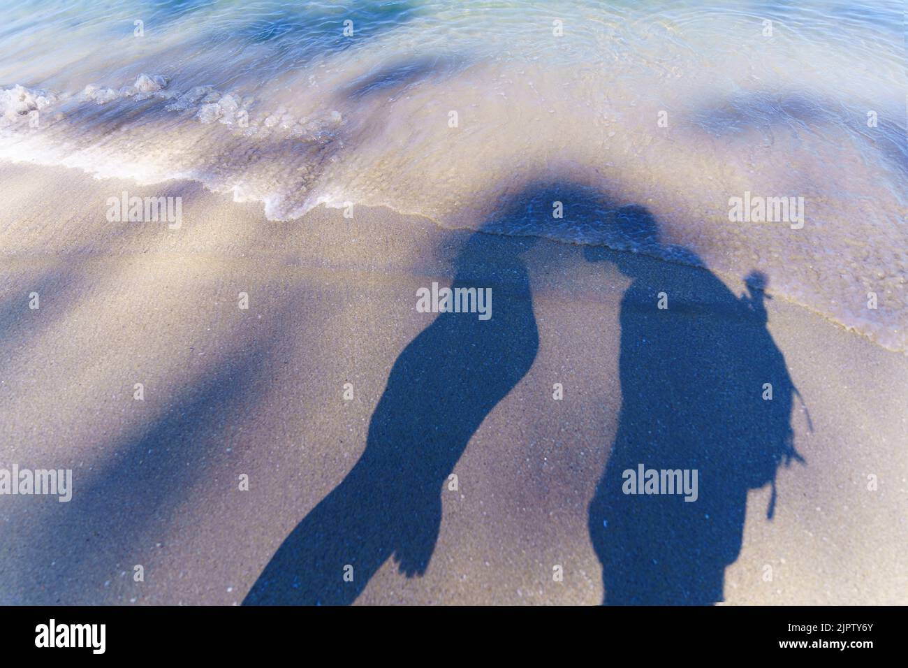 The shadow of two people on the seashore Stock Photo - Alamy