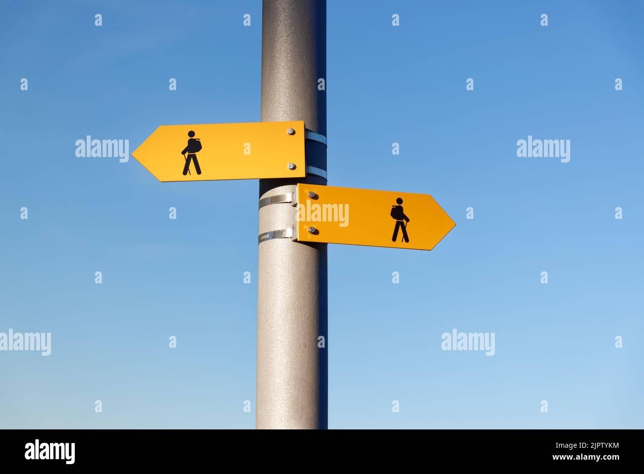 two yellow hiking trail signs with symbol person, backpack, hiking ...