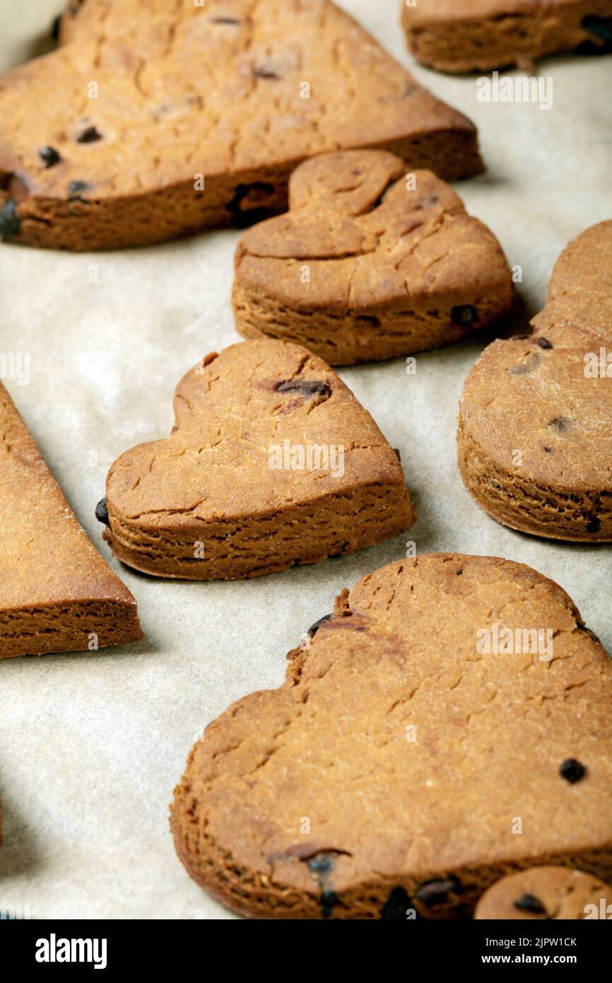 Heart shaped biscuits with chocolate drops on a baking tray Stock Photo ...