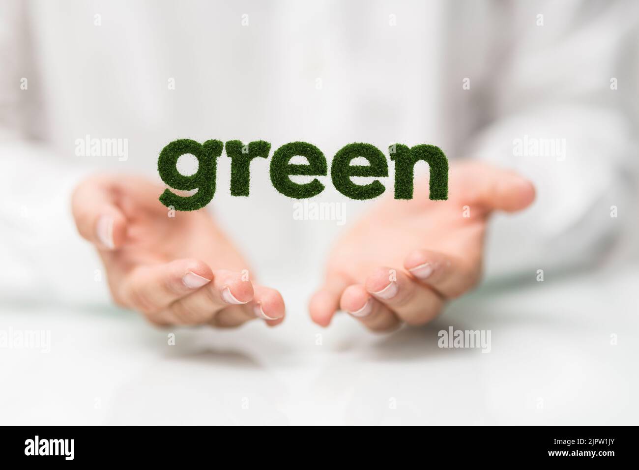 A 3D rendering of the word 'Green' made with grass above hands Stock ...