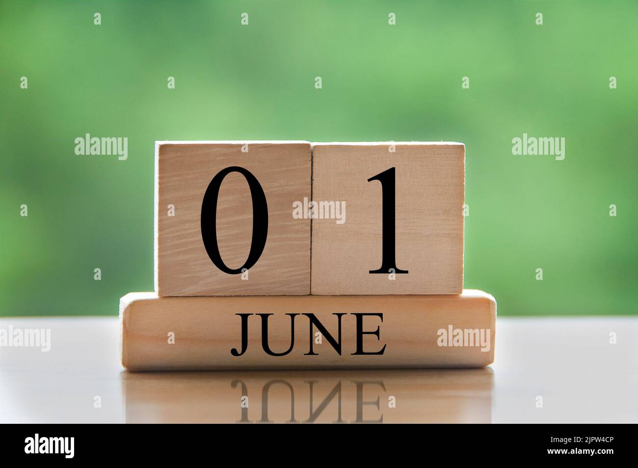 June 1 calendar date text on wooden blocks with blurred nature ...