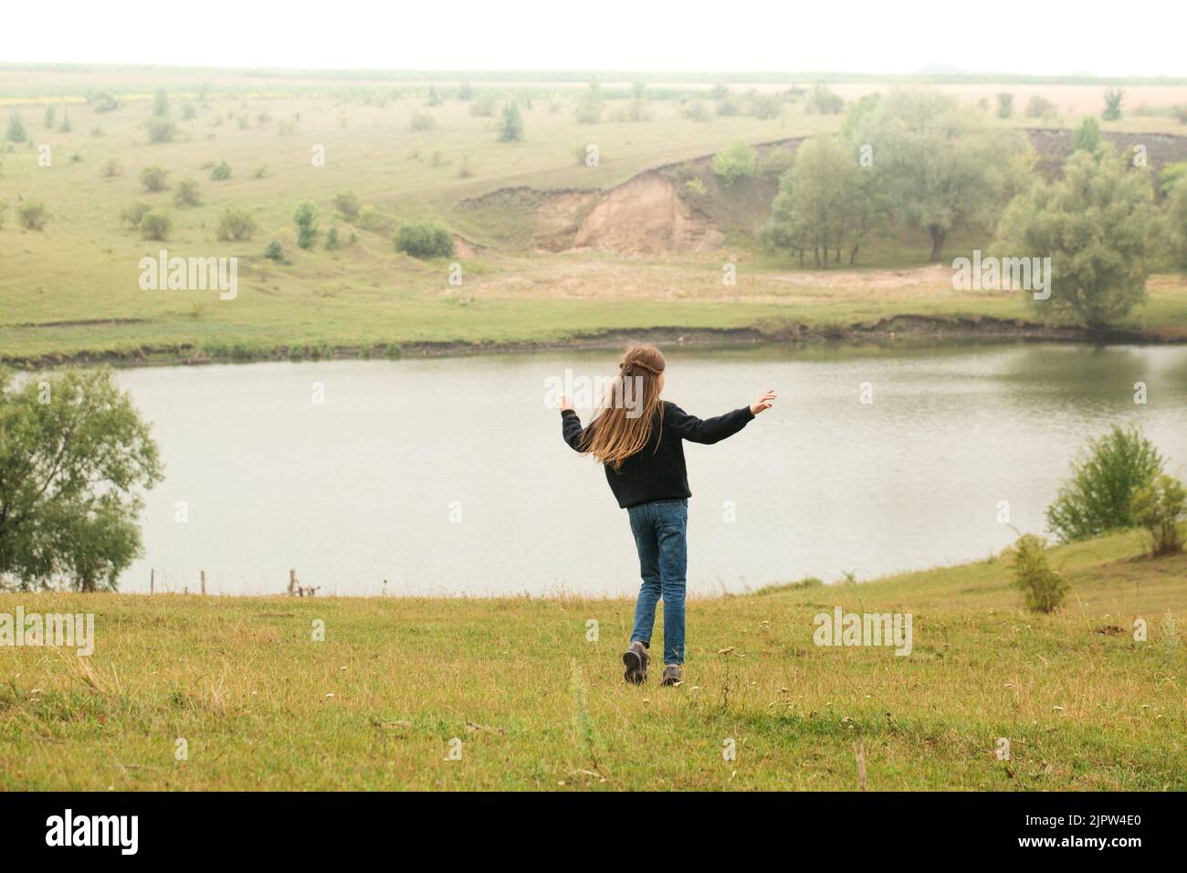 A teenage girl is having fun in a clearing by the lake Stock Photo - Alamy