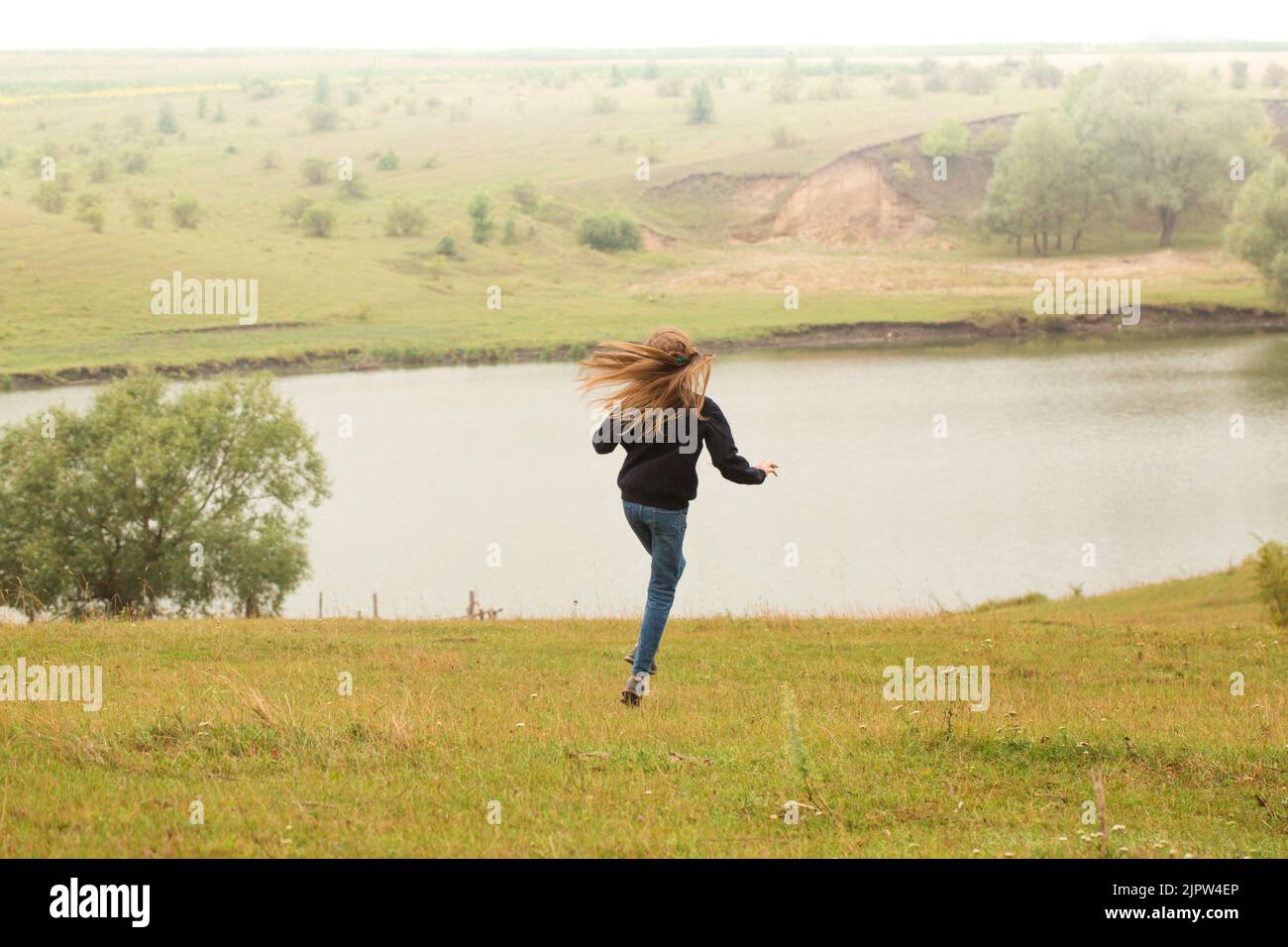 A teenage girl is having fun in a clearing by the lake Stock Photo - Alamy