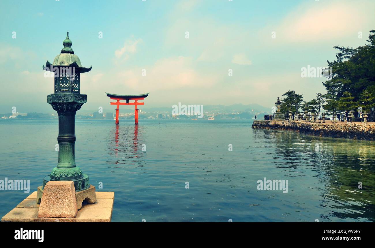 Bronze lantern and torii gate at Miyajima island, Itsukushima ...