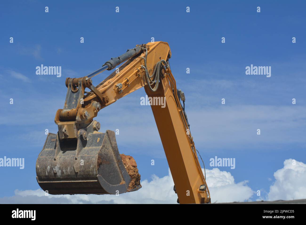 An excavator bucket backhoe with soil against the blue sky Stock Photo ...
