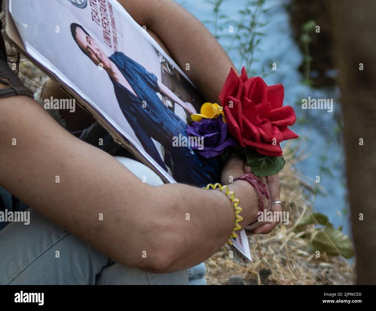 woman holding a photograph of Federico Garcia Lorca with flowers in the ...