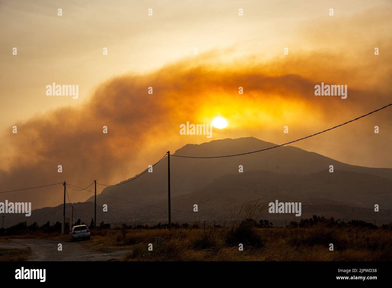 Scorace wood burn in the evening, covering the setting sun with smoke ...