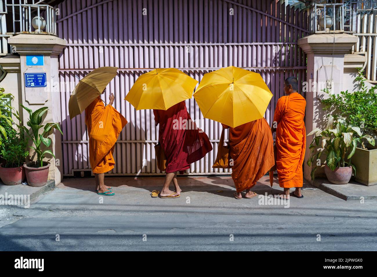 The four monks with colorful clothes and umbrellas collecting alms on ...