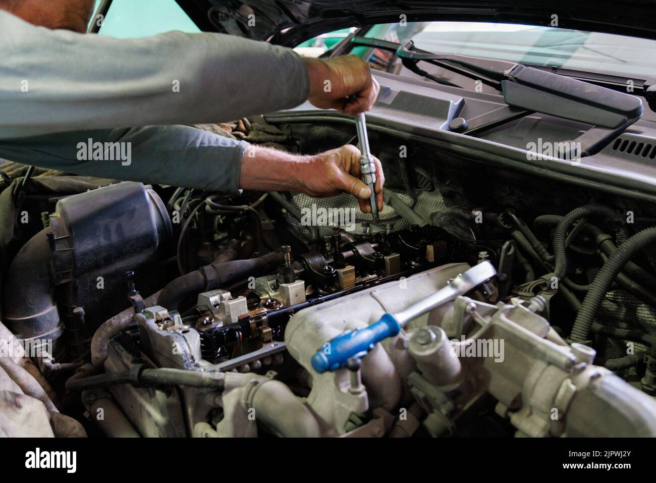 hands of caucasian mechanic unscrewing diesel engine parts of modern ...