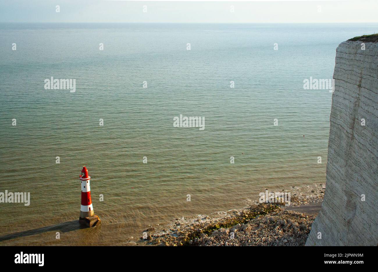 Beachy Head Lighthouse at high tide by the white cliffs near Eastbourne ...