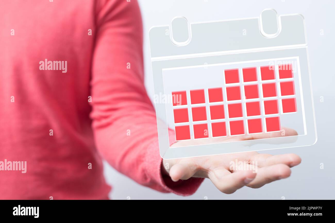 A closeup of a person holding an illustrative calendar with a white ...