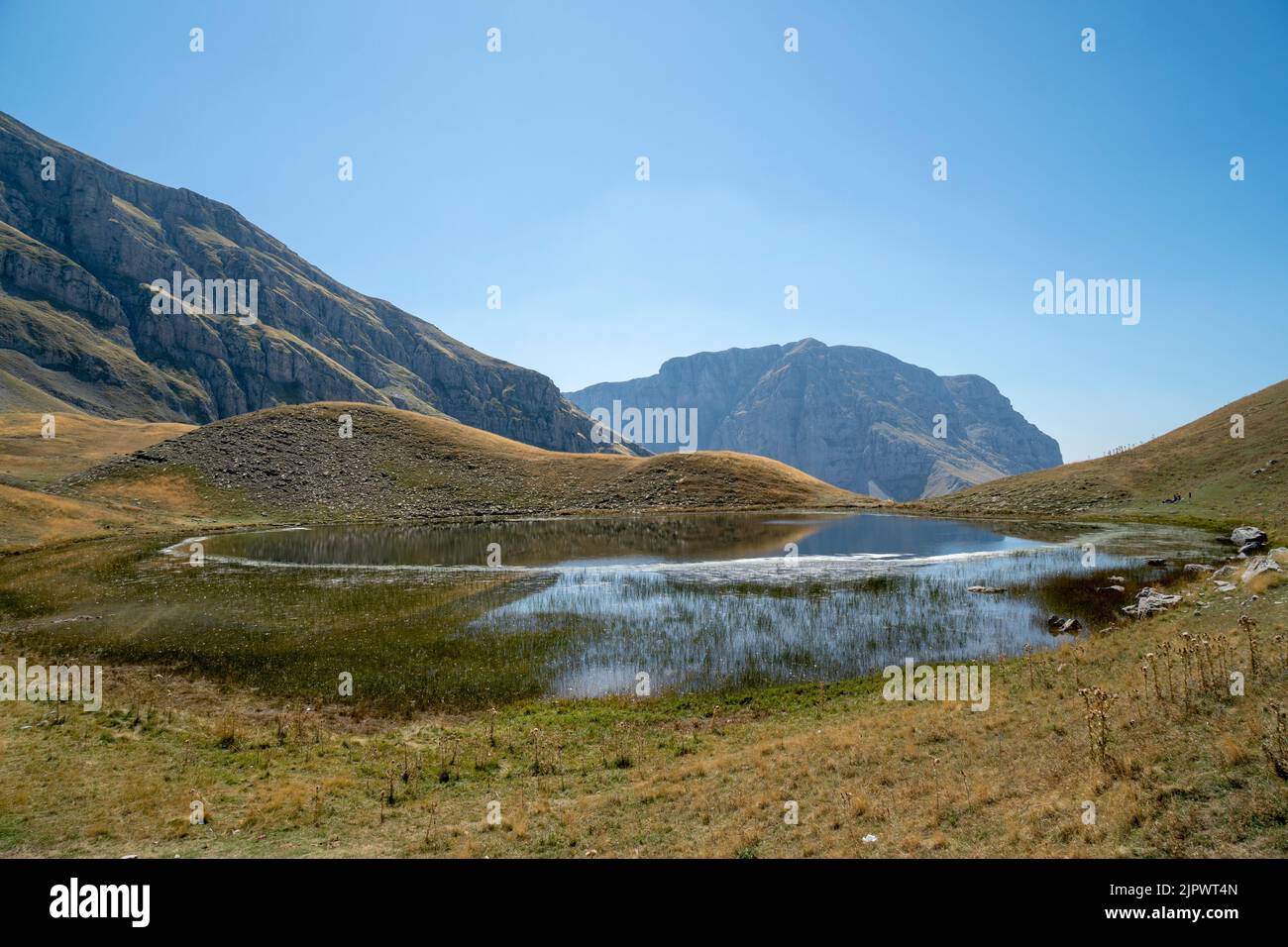 A beautiful view of a lake surrounded by hills under a clear sky Stock ...