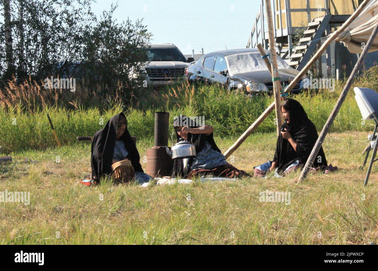 Women, wearing traditonal dress of the time, pour tea as they ...