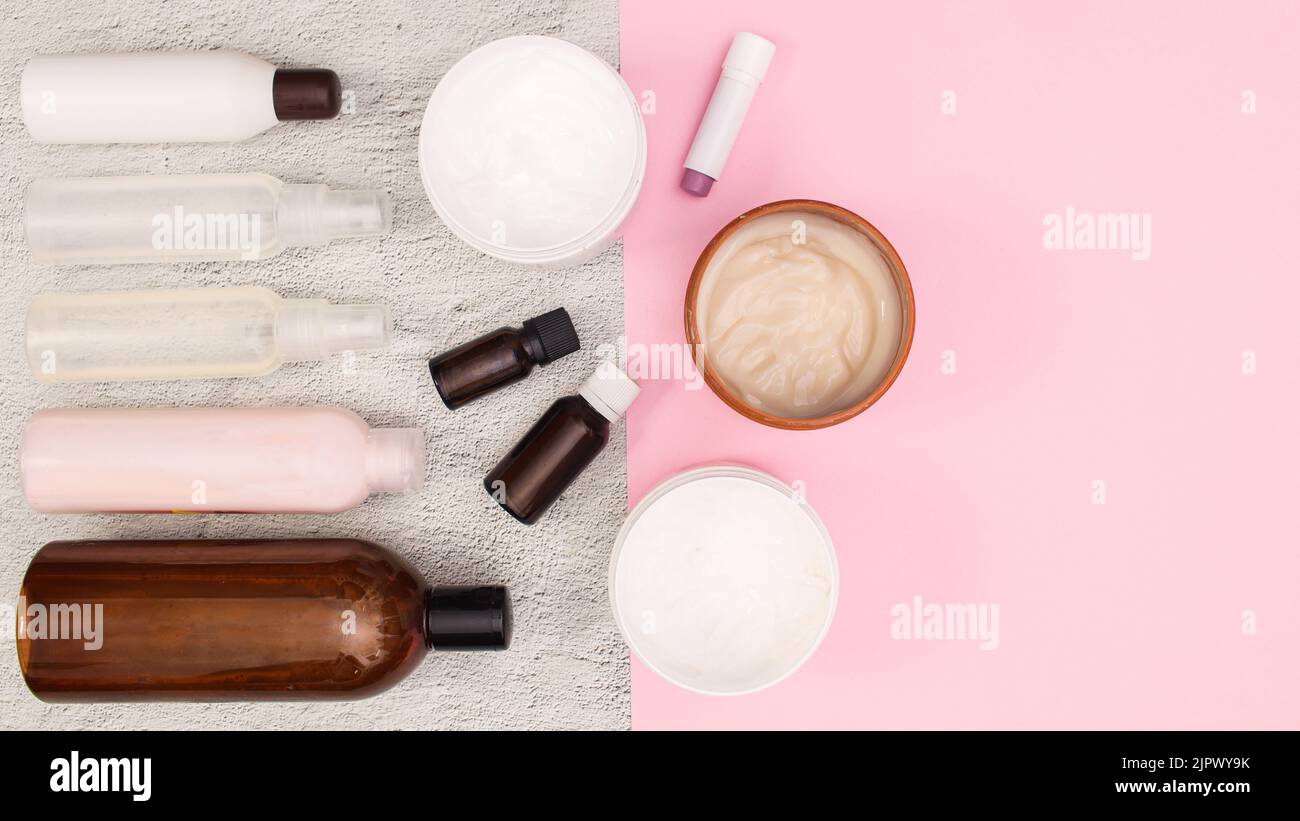 Bottles of Beauty and cosmetics products layout on white and pink ...