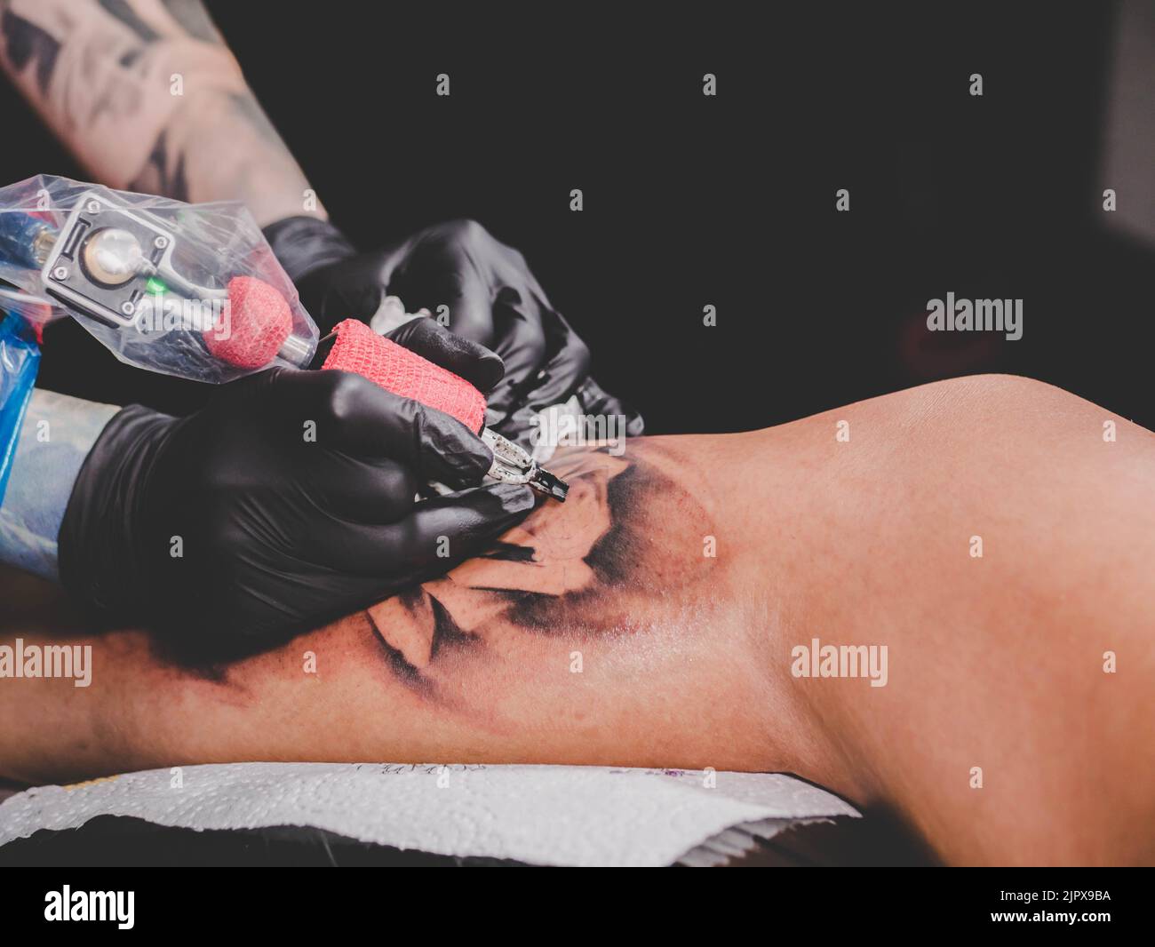 Close up view of tattoo artist demonstrates the process of getting ...