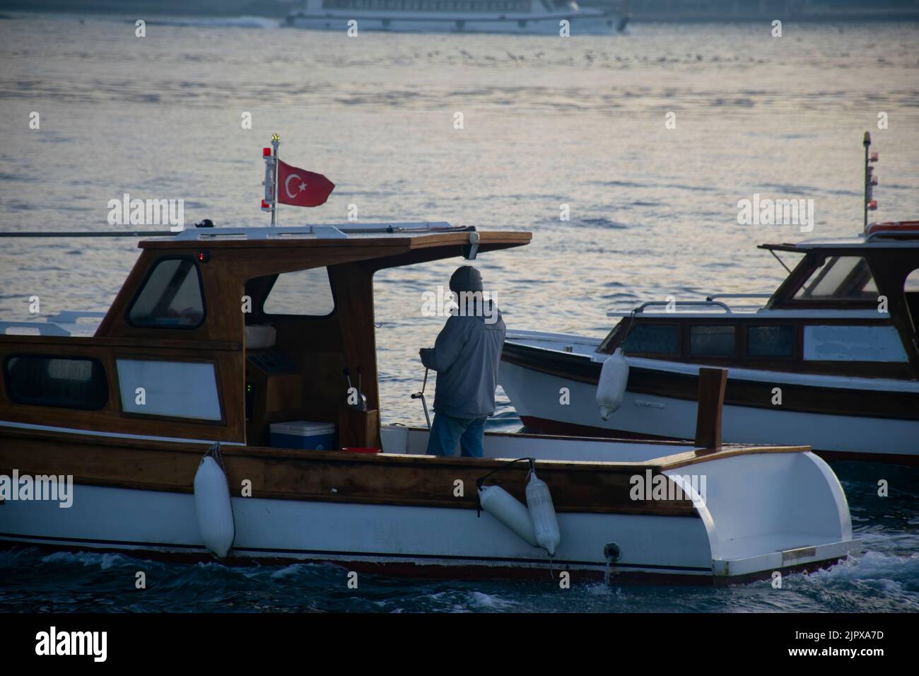 Men on a boat in Bosphorus waters in Istanbul. Fisherman in boat in ...