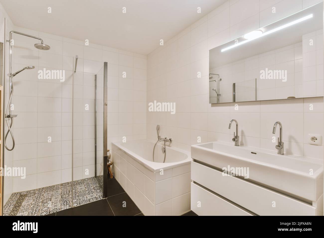 Sinks With Mirrors And Clean Bathtub Located Near Shower Box With Glass