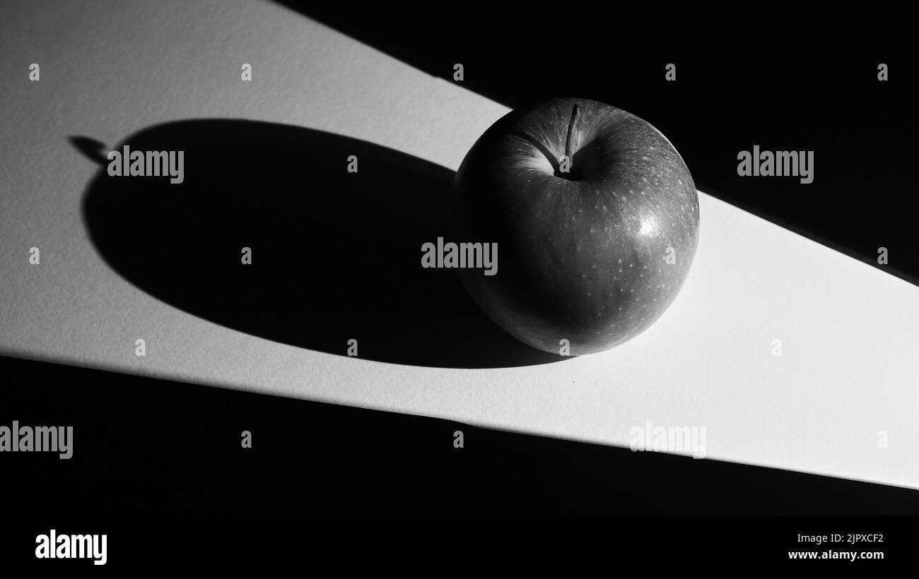 A grayscale of an apple on a white surface with a shadow Stock Photo ...