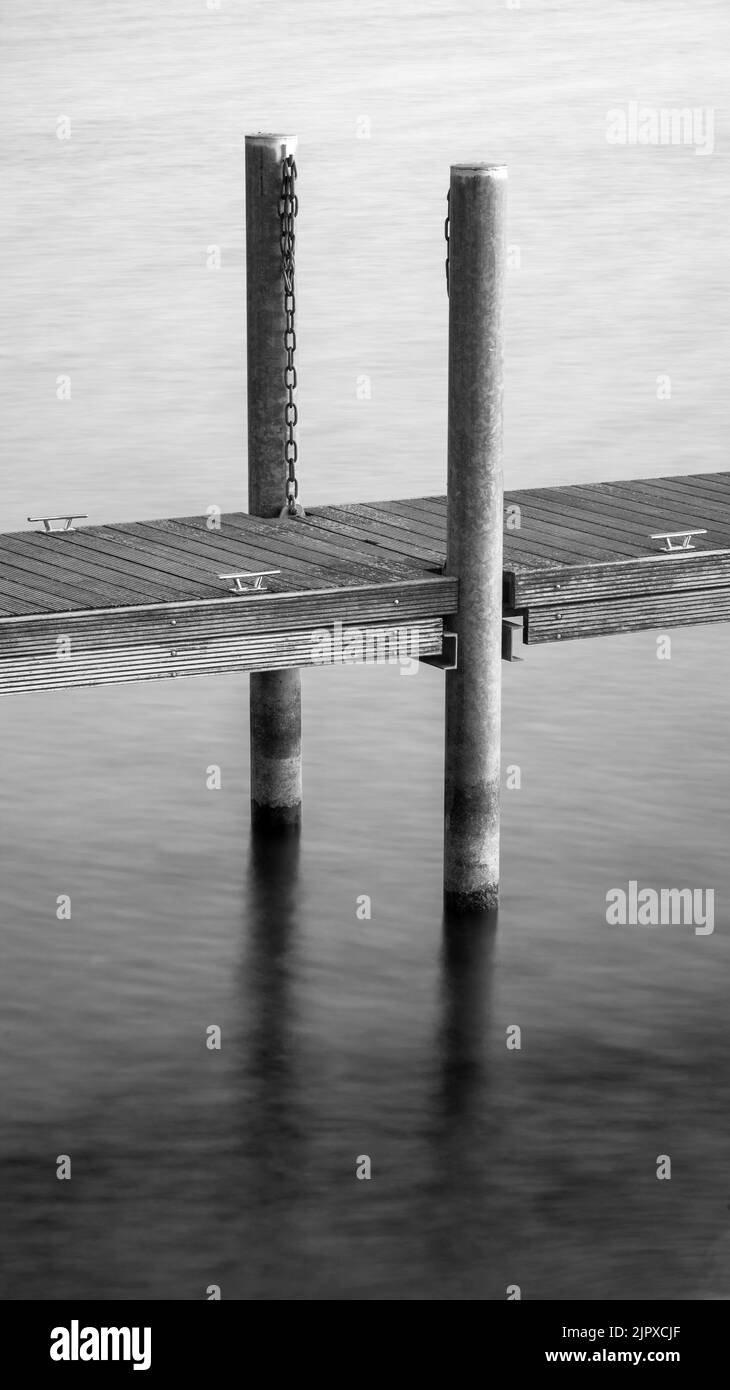 A grayscale of a pier with stone poles in a sea Stock Photo - Alamy