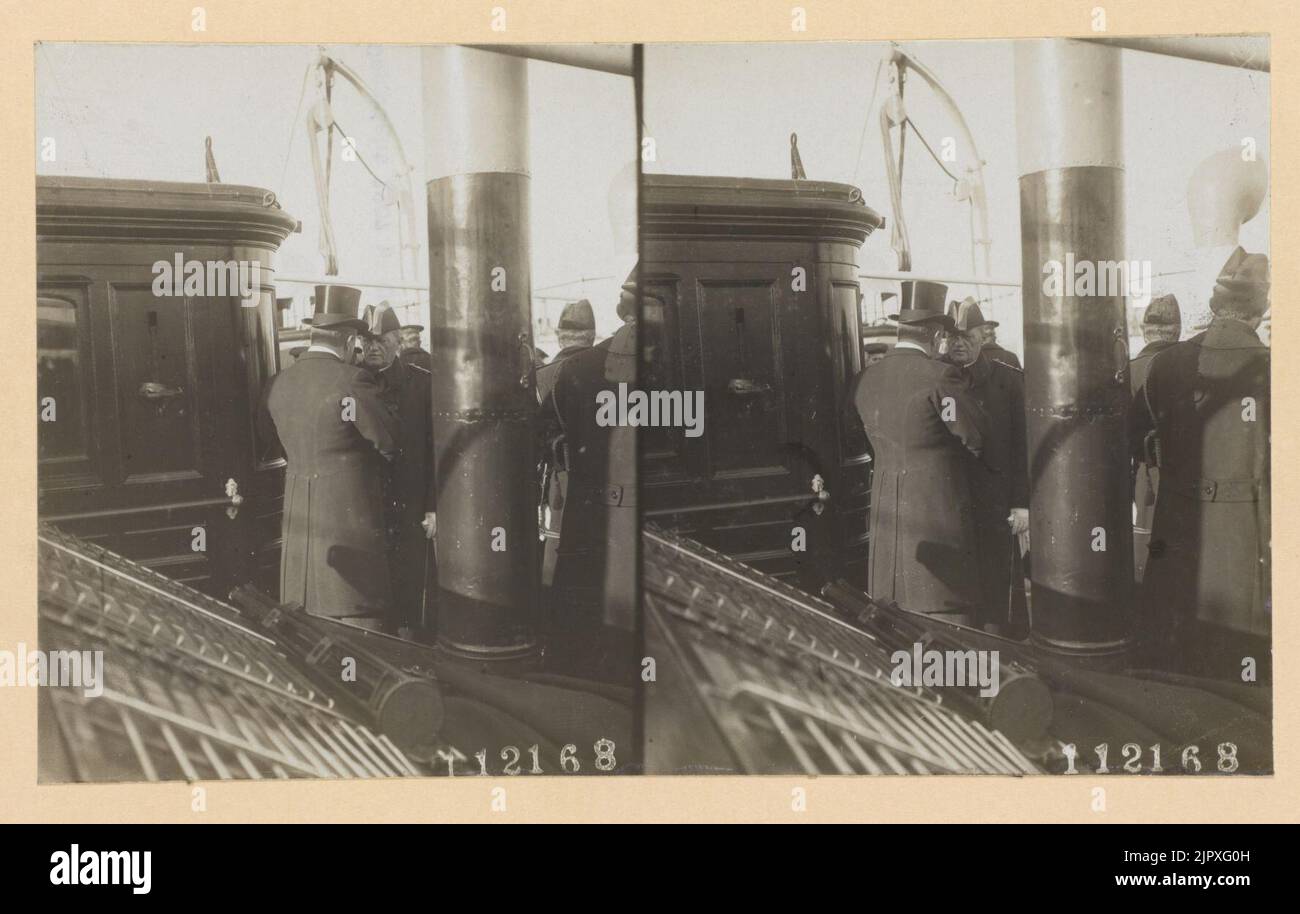 Theodore Roosevelt on deck of ship, back to camera, conversing with a ...