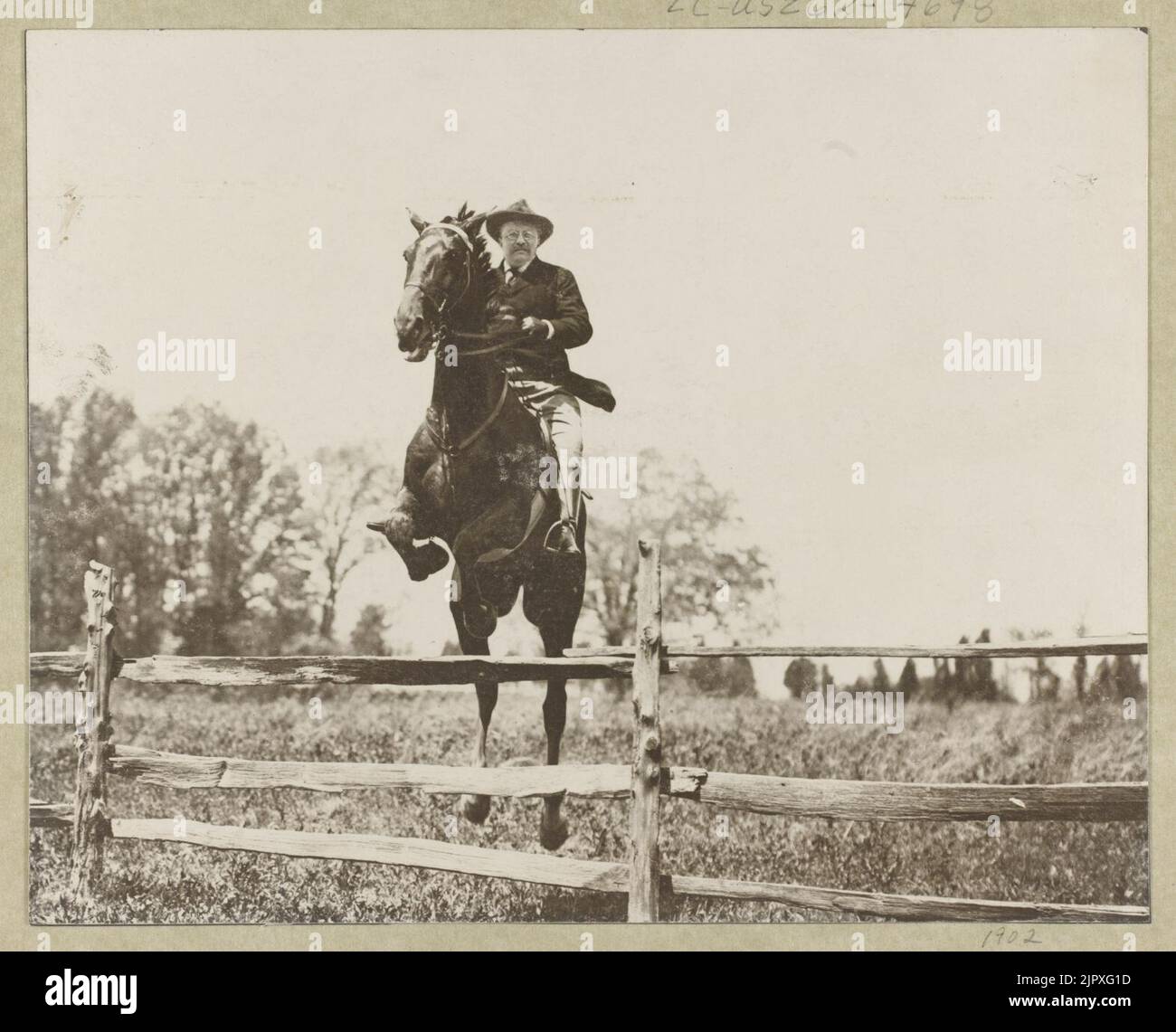 Theodore Roosevelt on horseback jumping over a split rail fence Stock ...