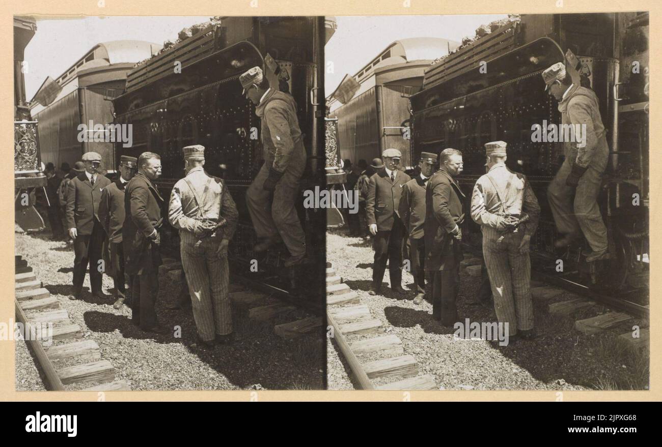 Theodore Roosevelt standing by a railroad car with workers and other ...