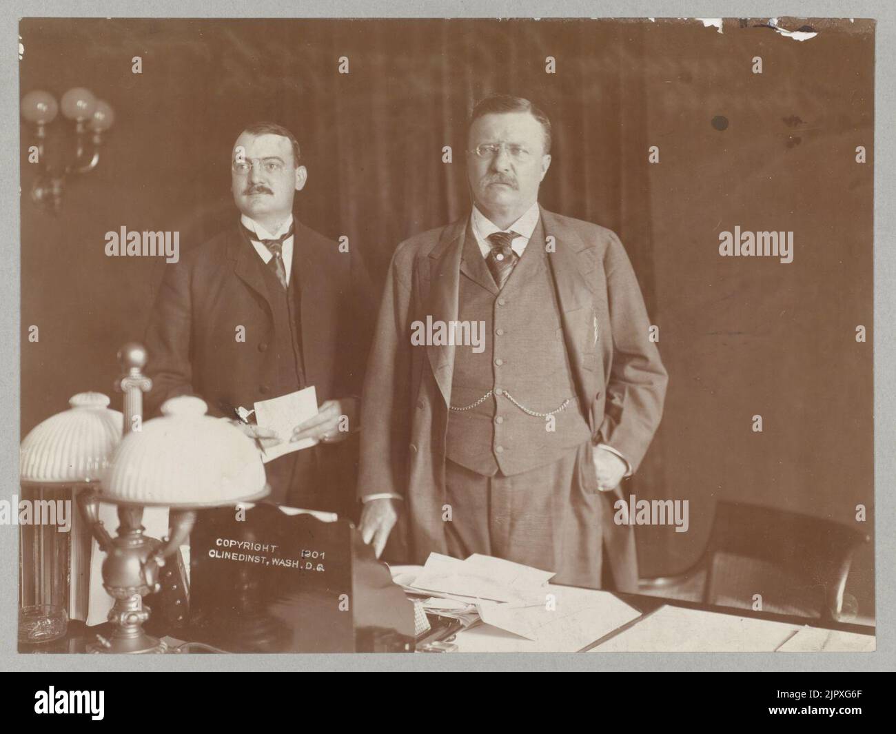 Theodore Roosevelt standing behind desk, facing slightly left, with ...