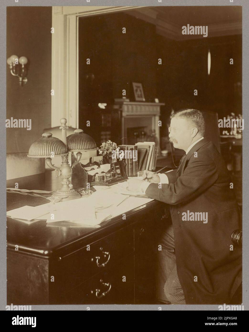 Theodore Roosevelt, full-length portrait, seated at his desk writing ...