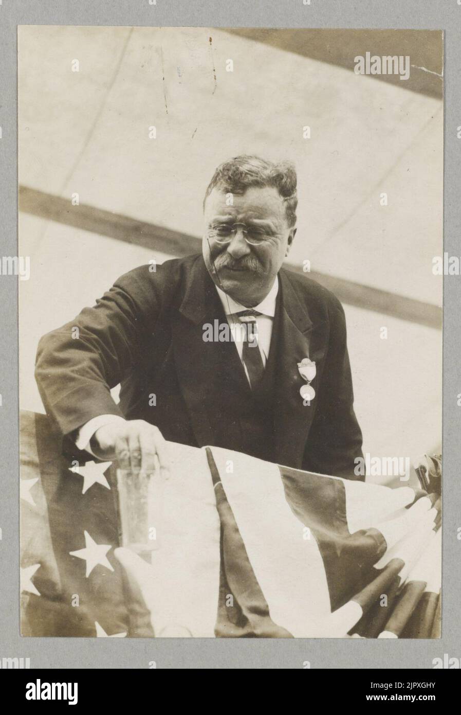 Theodore Roosevelt, leaning over flag-draped railing Stock Photo - Alamy