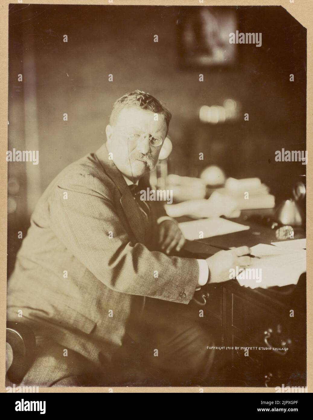 Theodore Roosevelt, three-quarter length portrait, seated at his desk ...