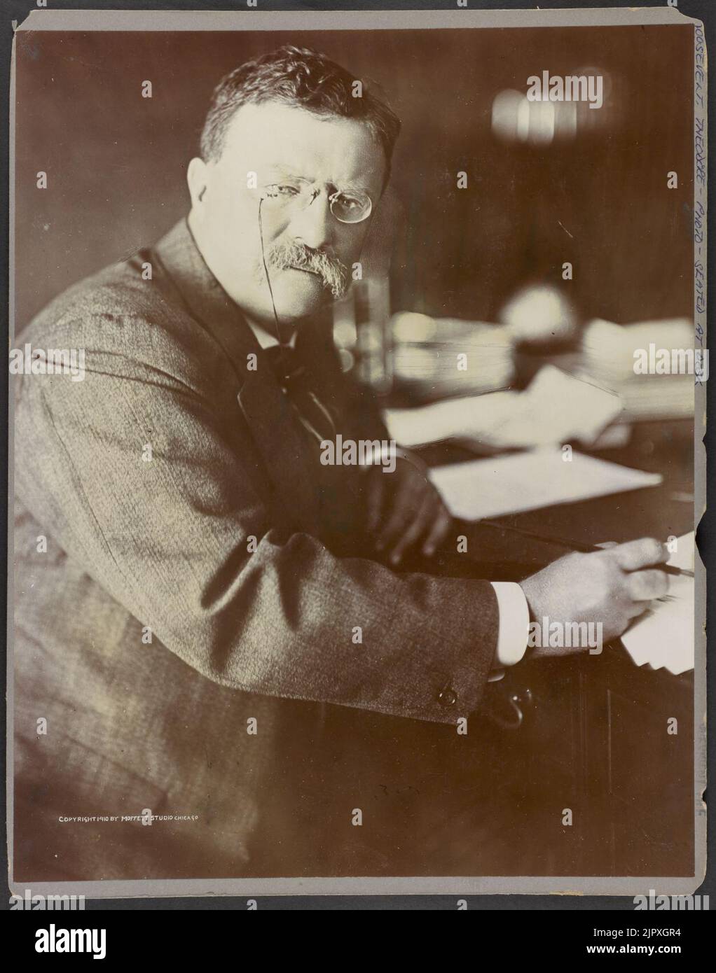 Theodore Roosevelt, three-quarter length portrait, seated at his desk ...