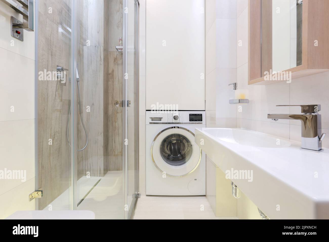 Washing machine in the bathroom interior Stock Photo - Alamy